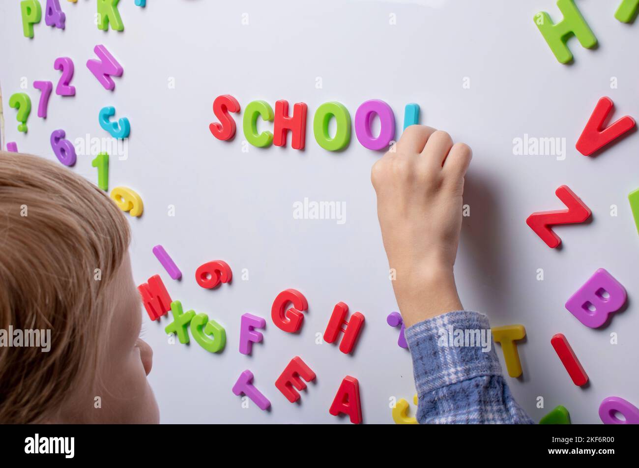 Word school made from colorful letters. Boy making words Stock Photo ...