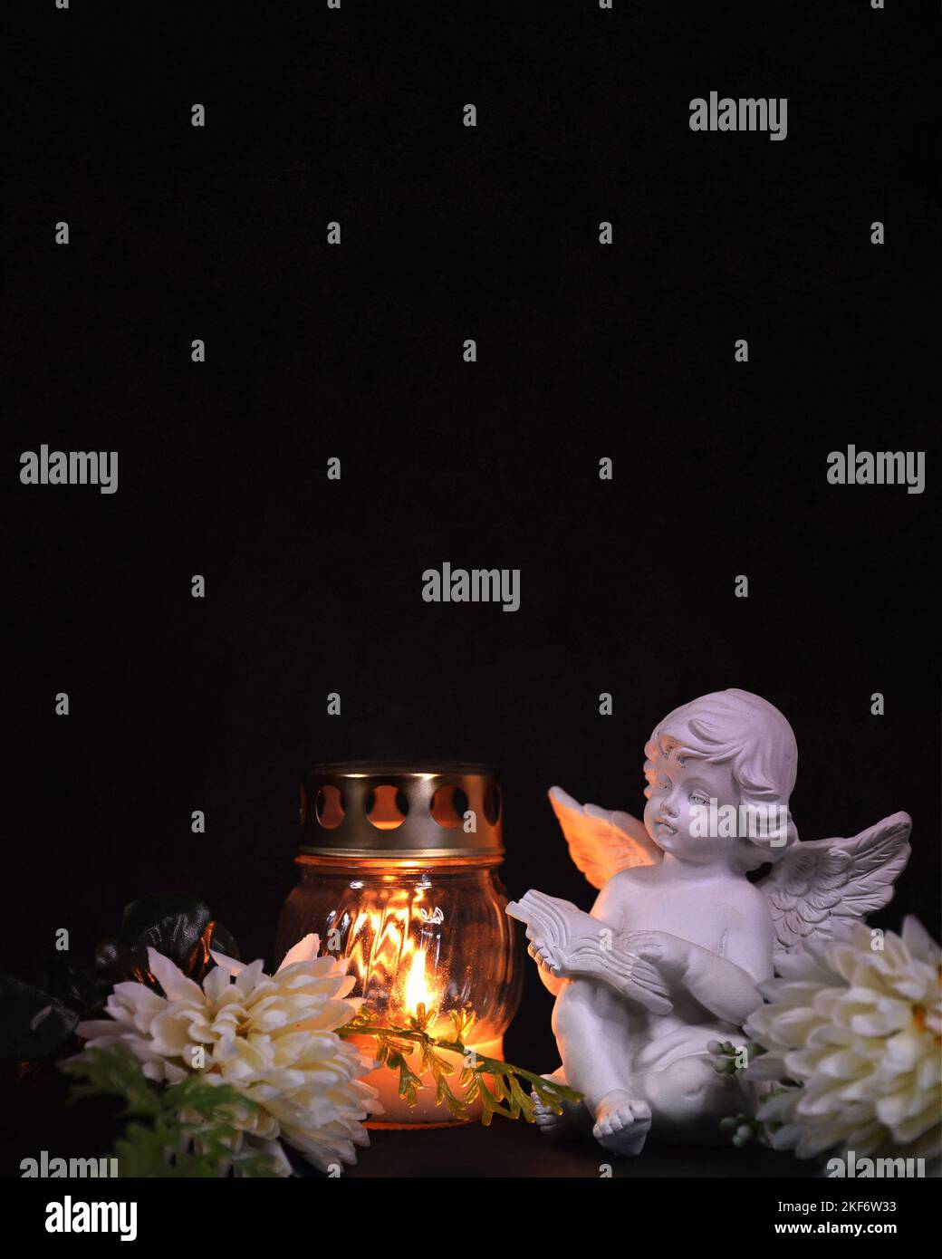 Funeral candle, flower and an angel on black background. Sympathy card ...