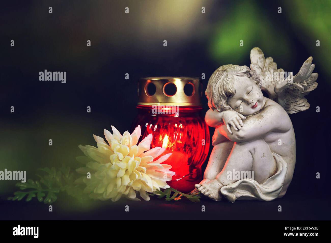 Funeral candle, flower and angel figurine on black background. Sympathy ...