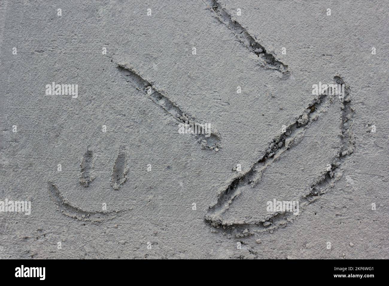 Happy smile scratched into the surface of the concrete sidewalk Stock ...