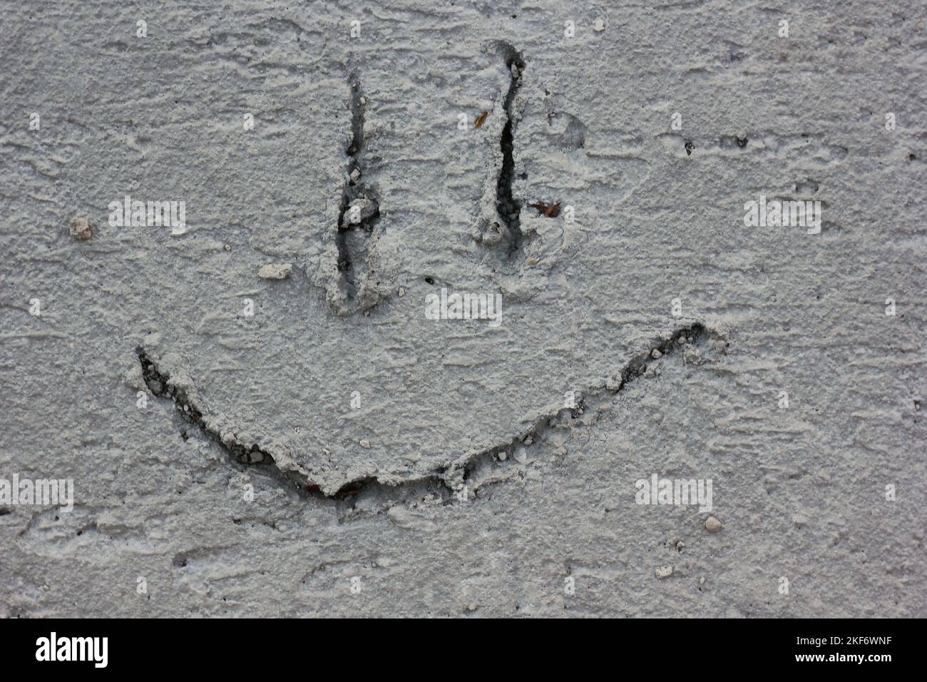Happy smile scratched into the surface of the concrete sidewalk Stock ...