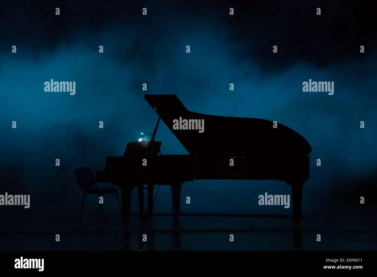 Piano in dramatic ambiance in concert hall, deep color. Silhouette ...