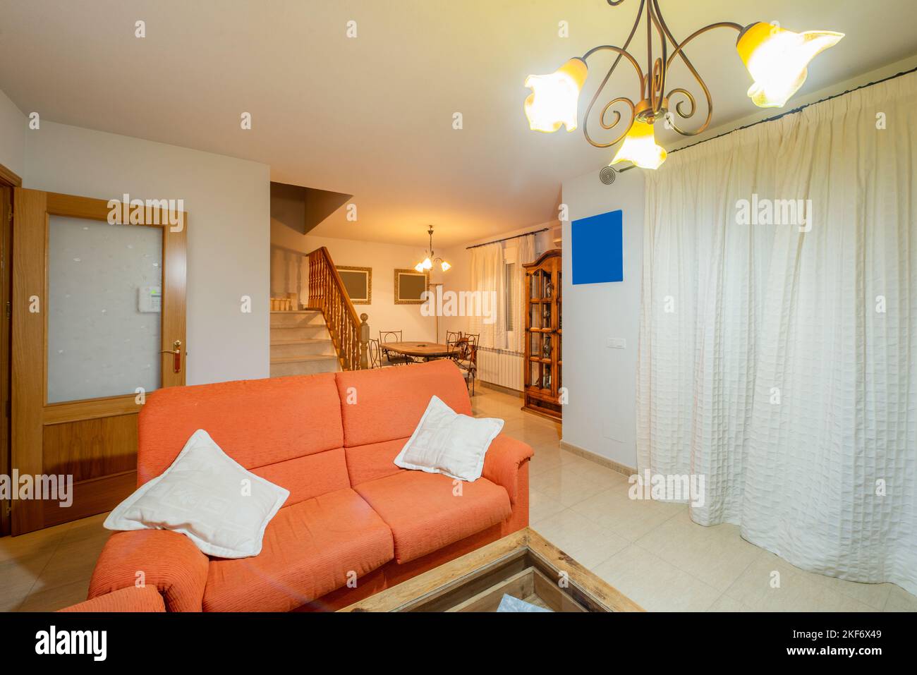 Living room with red fabric sofa, window with thick curtains and ...