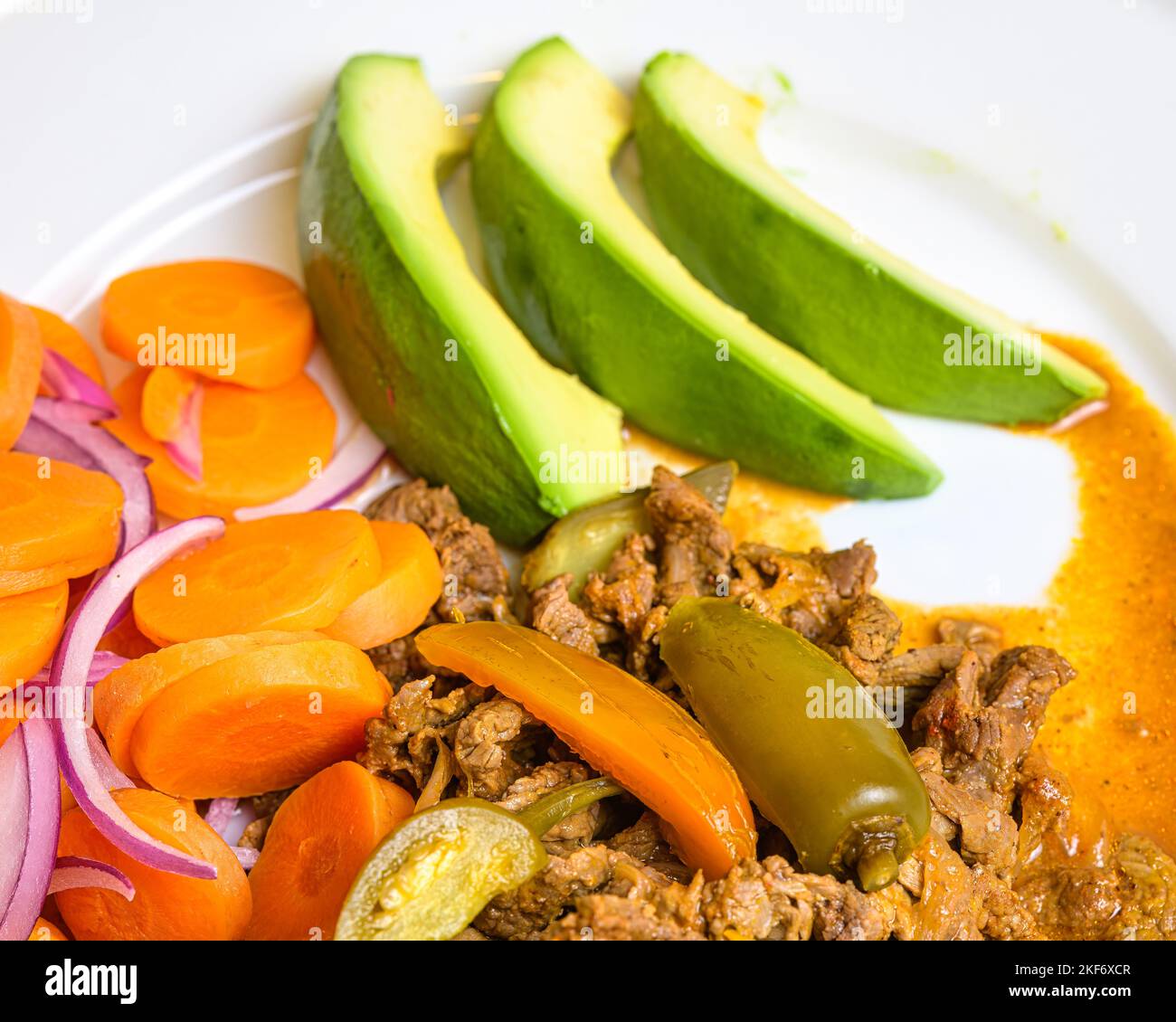 Cooked beef with boiled carrots and slices of avocado Stock Photo - Alamy