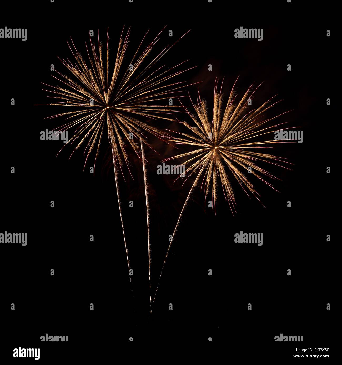 Two large exploding fireworks and a streak of a third one, isolated on ...