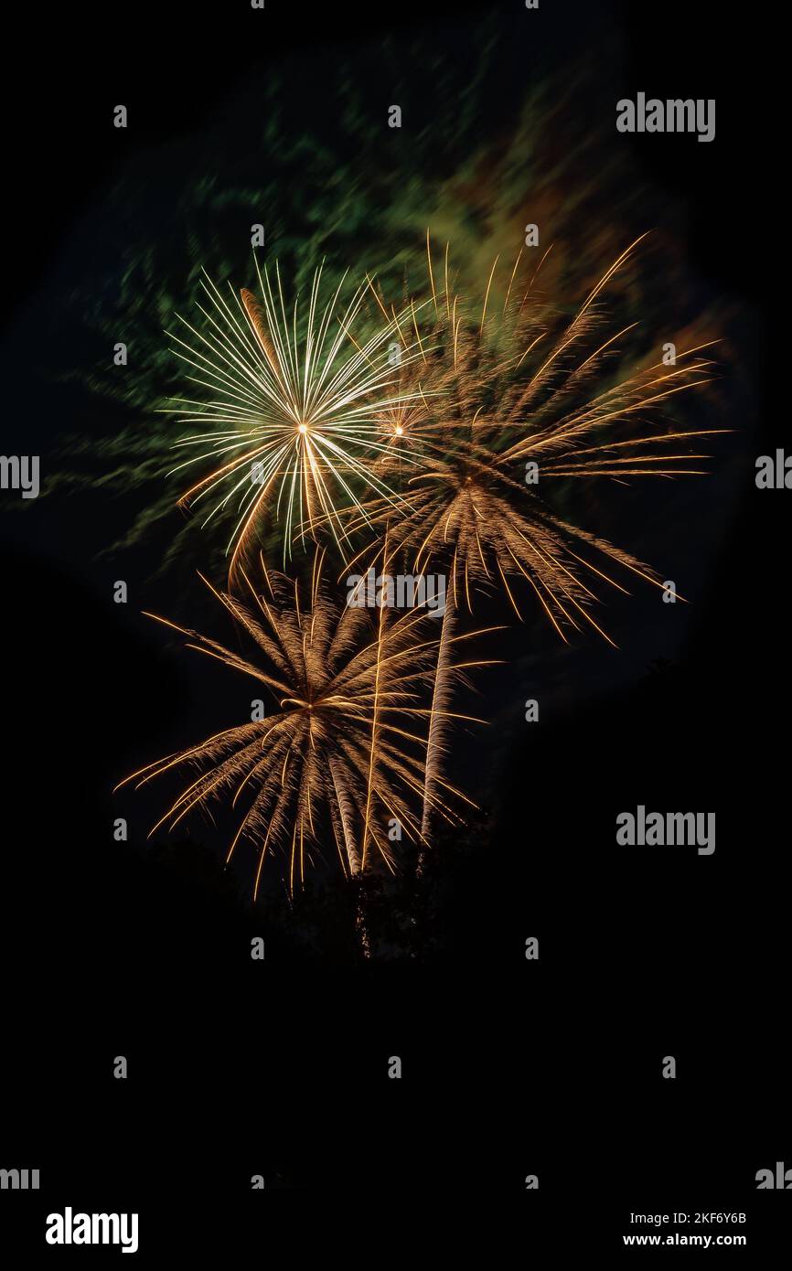 Multiple exploding fireworks in an evening sky, during a celebration ...