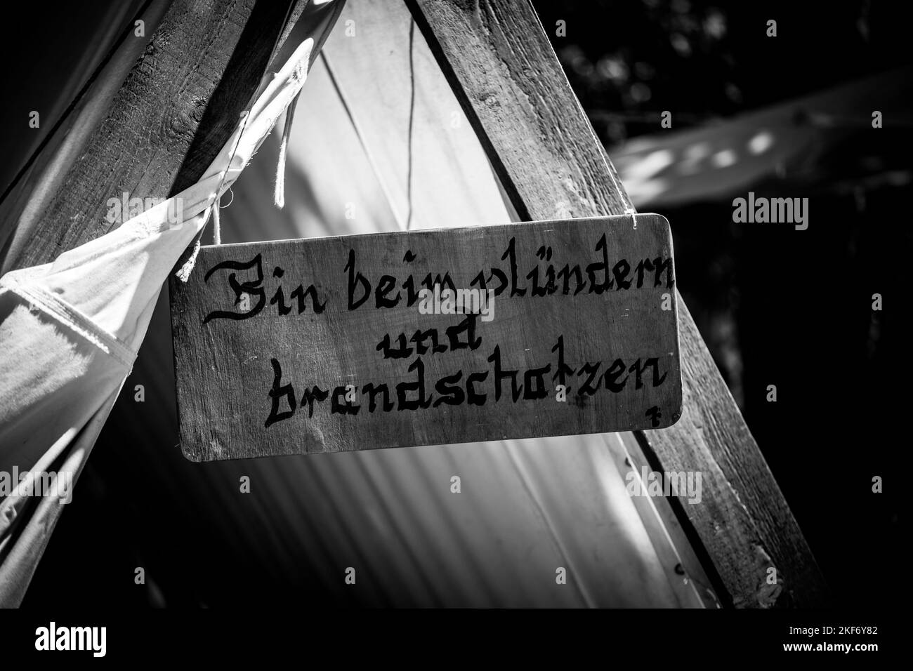 A grayscale of a sign hanging out of a tent saying I'm looting and ...