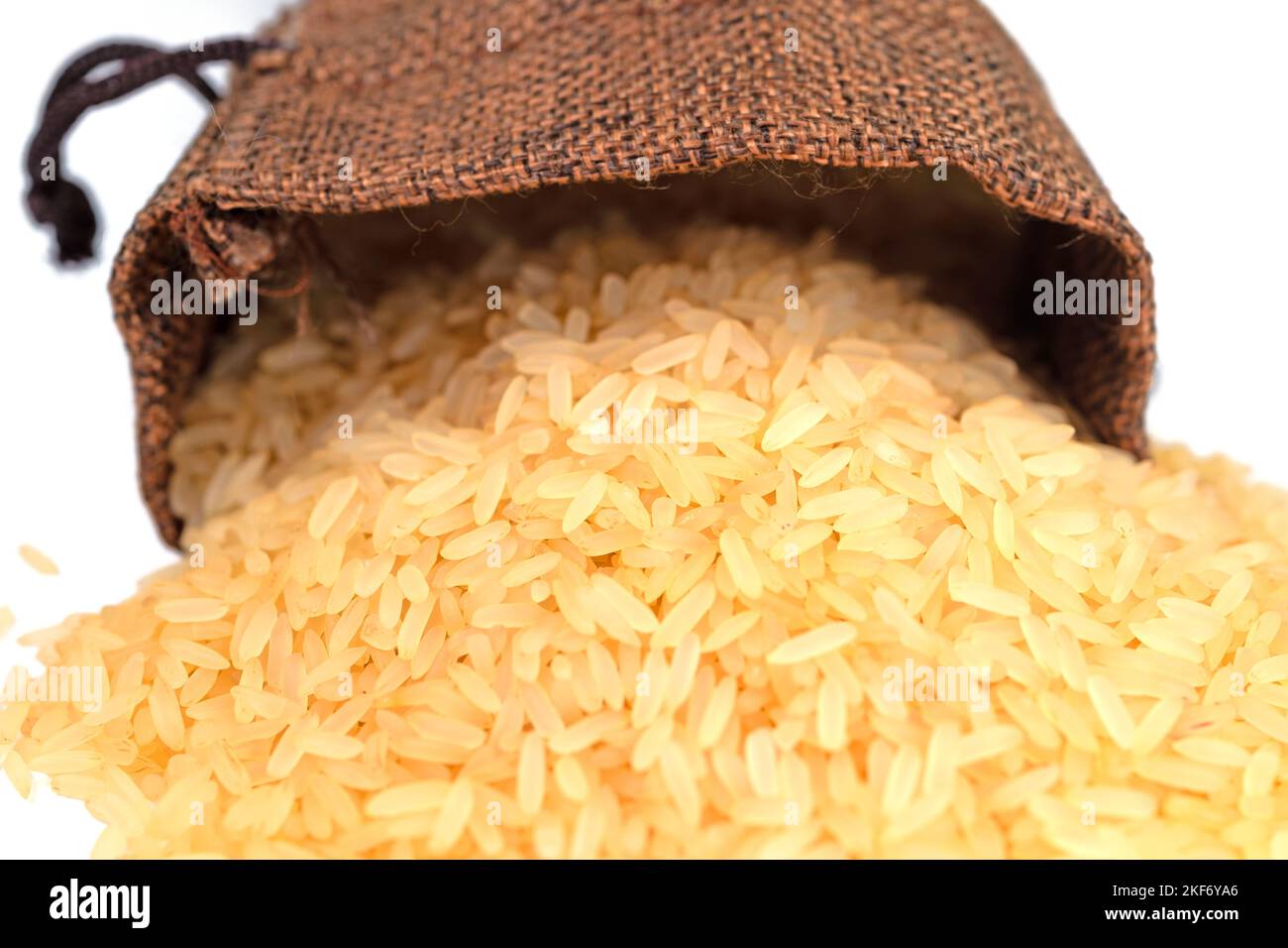 Rice grains in jute sack against white background Stock Photo - Alamy