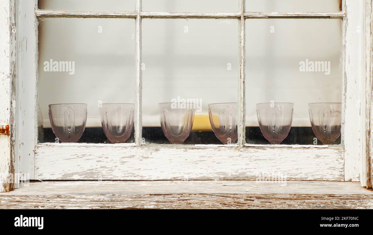 Glasses are lined up in the window of an old cabin at the Grand View ...
