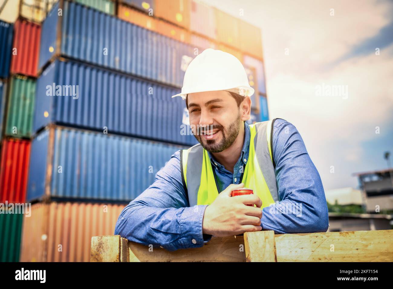 Handsome Engineer or foreman wears PPE checking container storage with ...