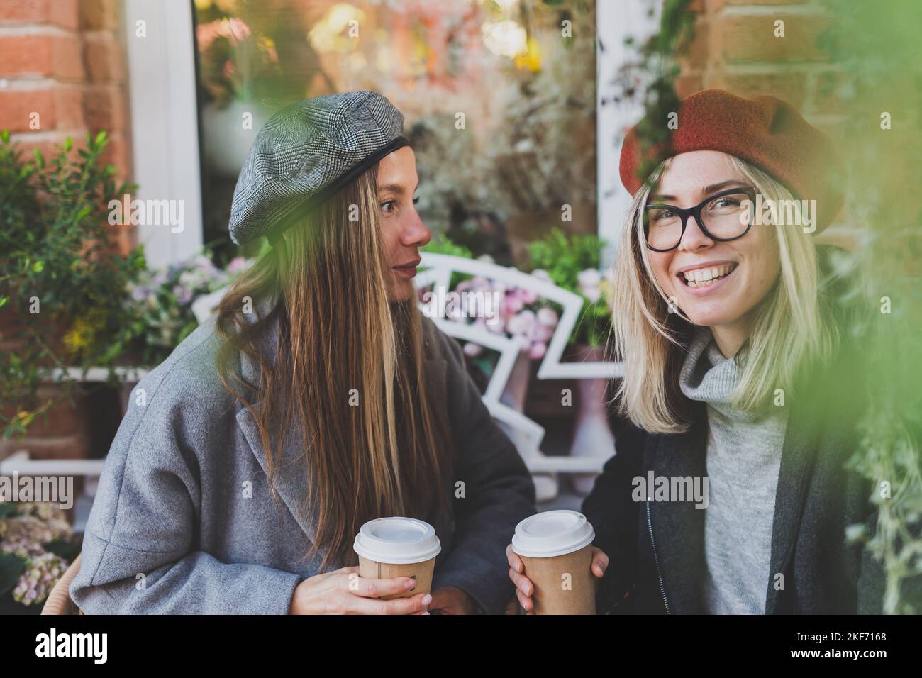 Portrait young female best friends talking to each other discussing ...