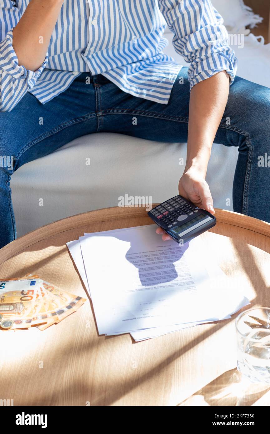 Vertical view of young man making calculations about the contract and ...