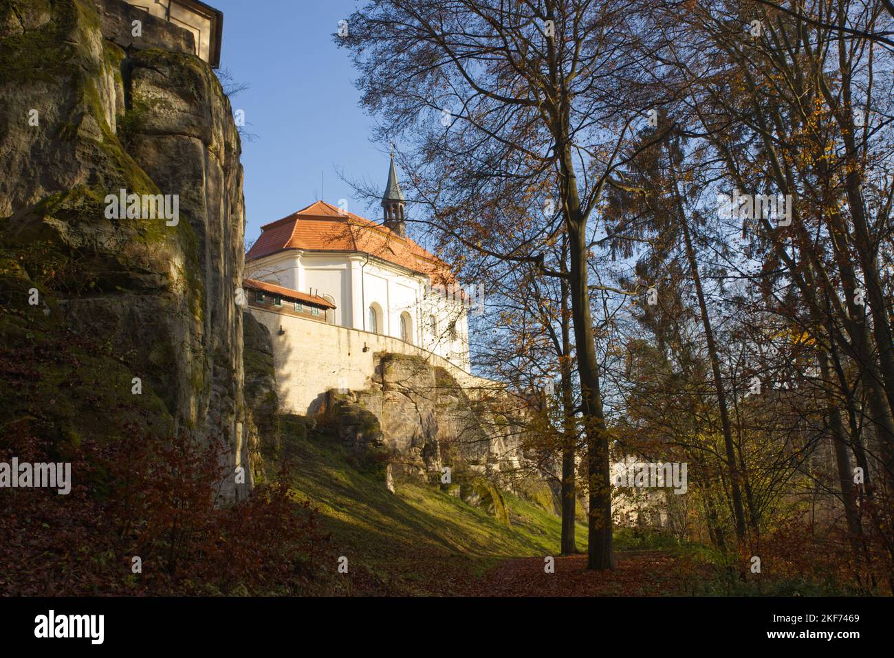 European medieval castle situated in forest in the autumn day, blue sky ...