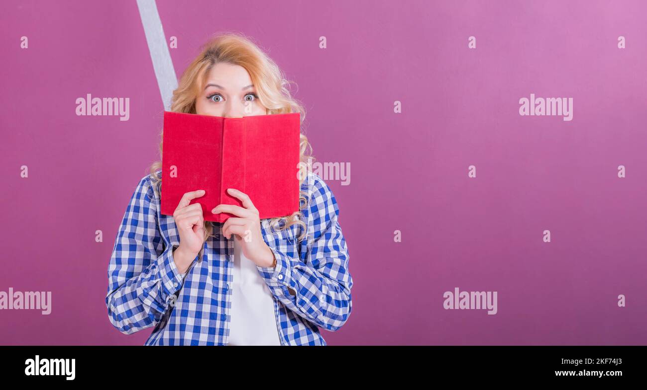 Young girl blonde covered half her face from below with red book and ...