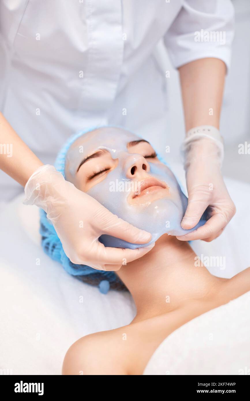 beautician removing mask from face of beautiful woman Stock Photo - Alamy