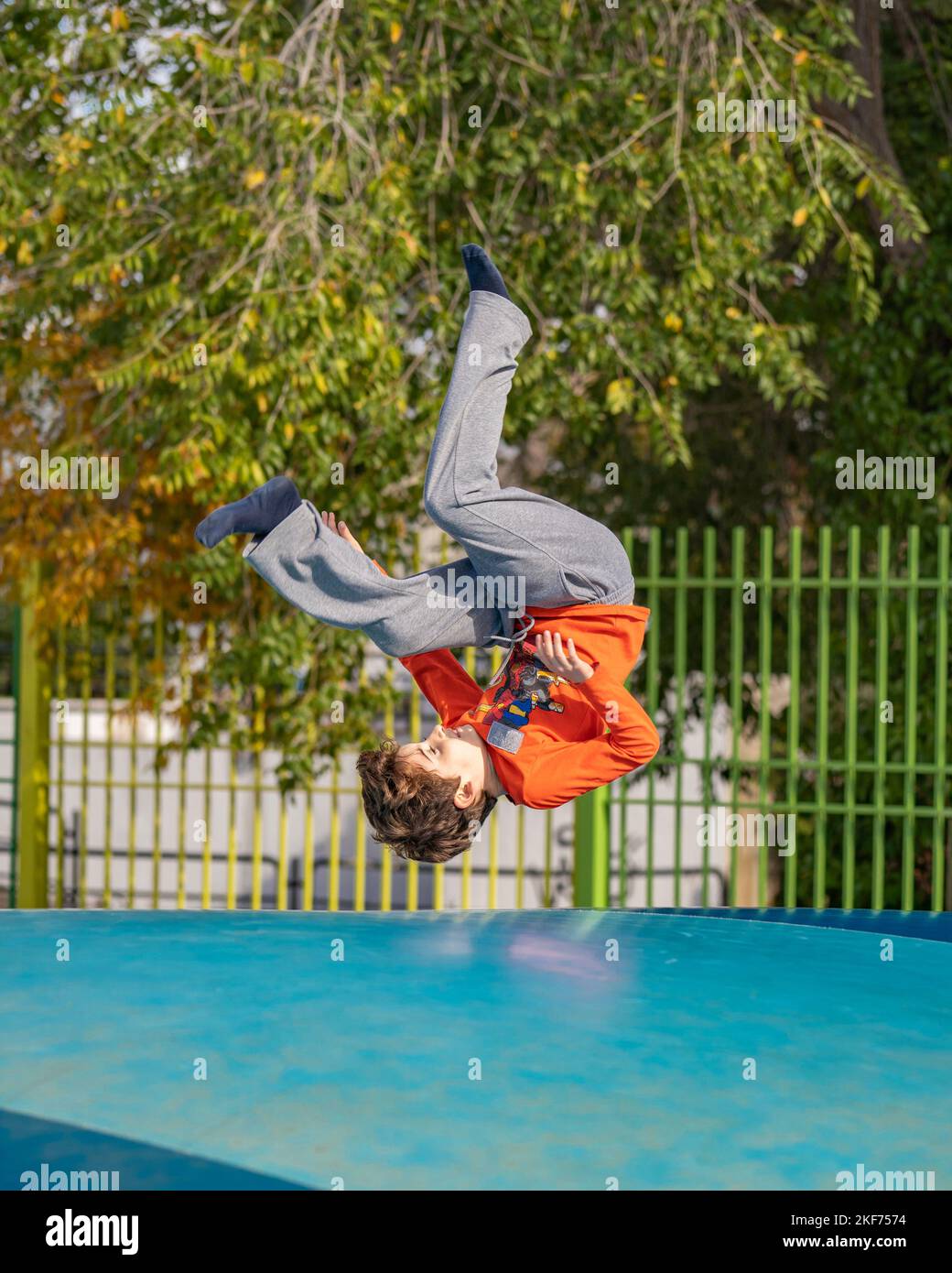 healthy sport little caucasian boy jumping somersault outdoors nature ...
