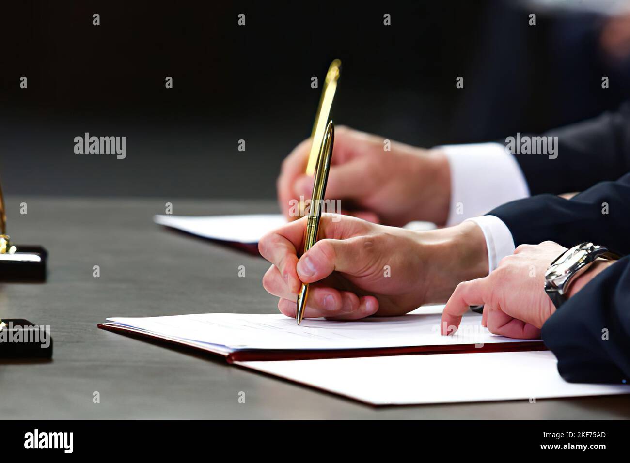 Golden parker in a man's hand, close up. The man signs the contract ...