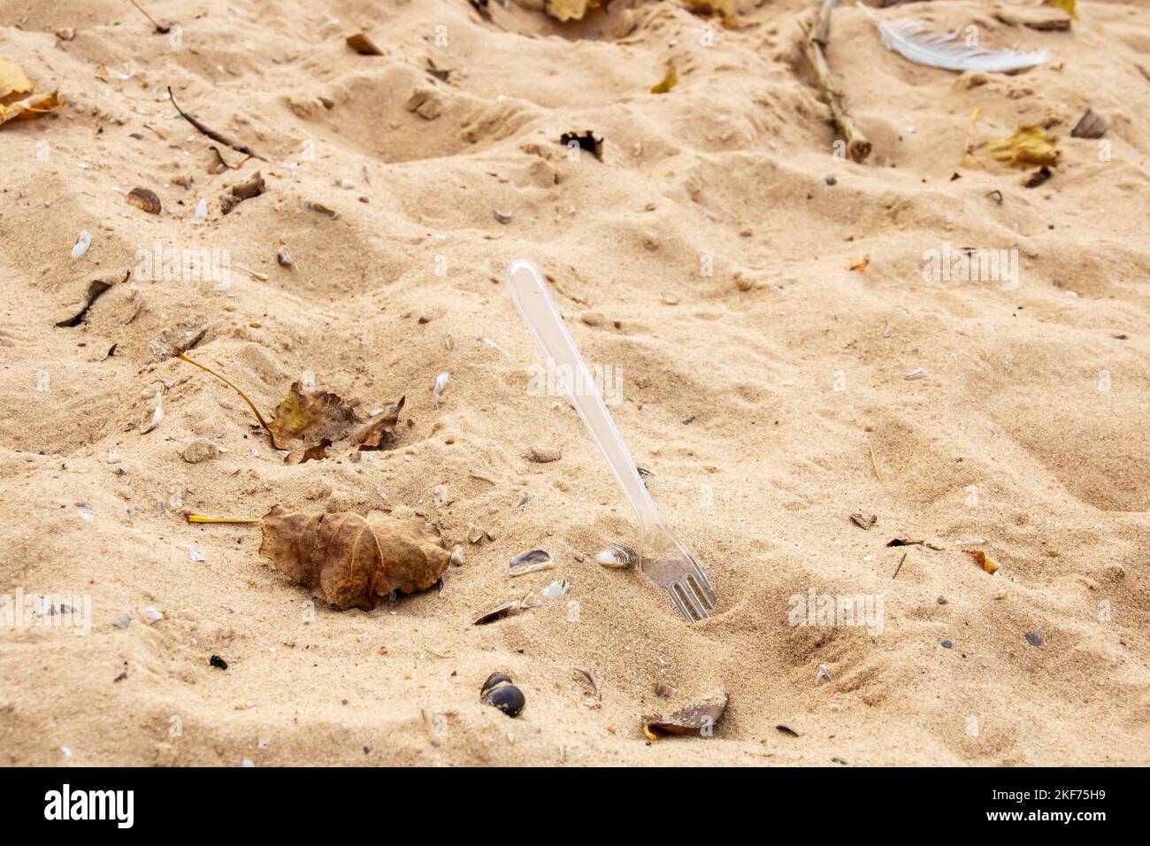 Plastic fork in the sand on the beach close up Stock Photo - Alamy