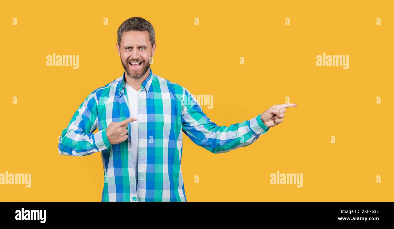 bearded caucasian man in shirt pointing finger isolated on yellow ...