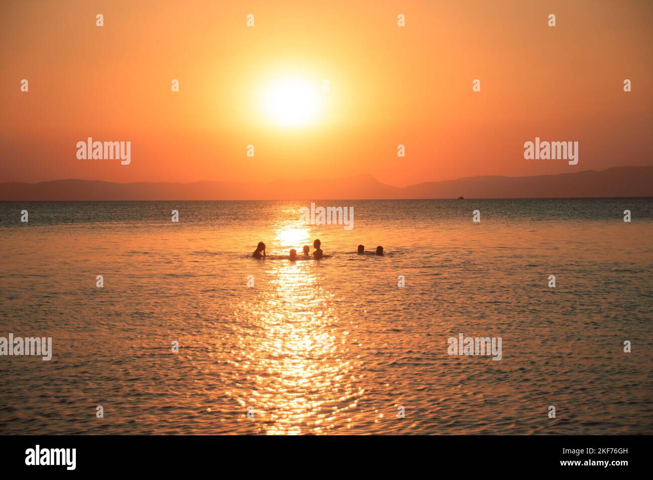 Silhouettes of people enjoying the warm sea during the sunset in Koh ...