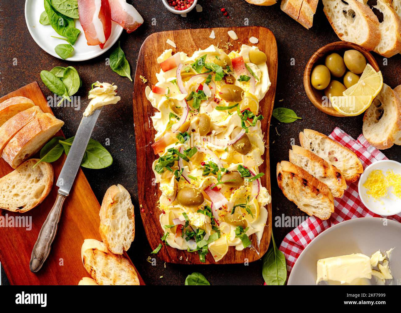 Homemade trendy butter board with onion, olives, herbs and bread ...