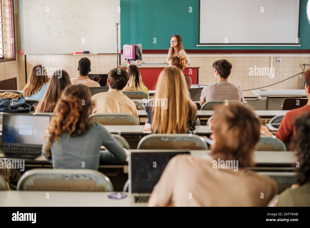 Professor explaining from her chair to her university students the ...