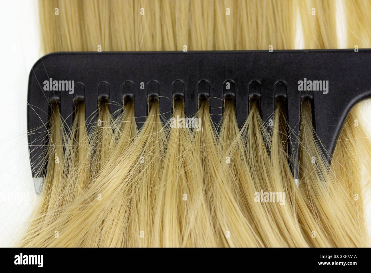 Different professional hairdresser tools black comb with strand of ...