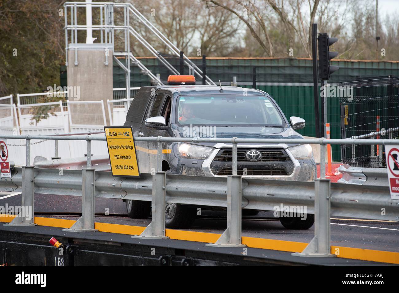 Harefield, UK. 16th November, 2022. An HS2 Security worker drives across a temporary bridge that ...