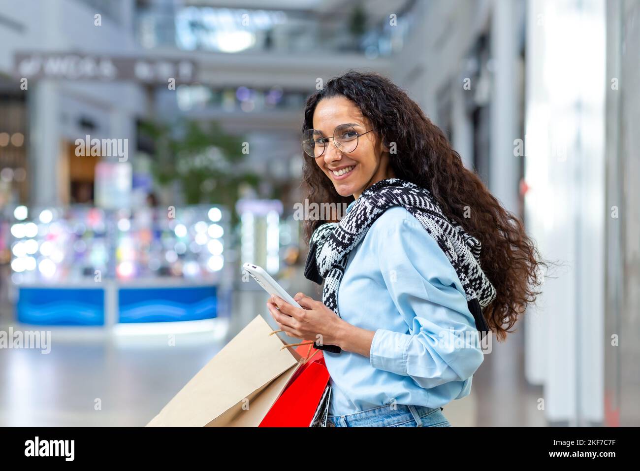 Beautiful young Latin American girl student shopping in a supermarket ...