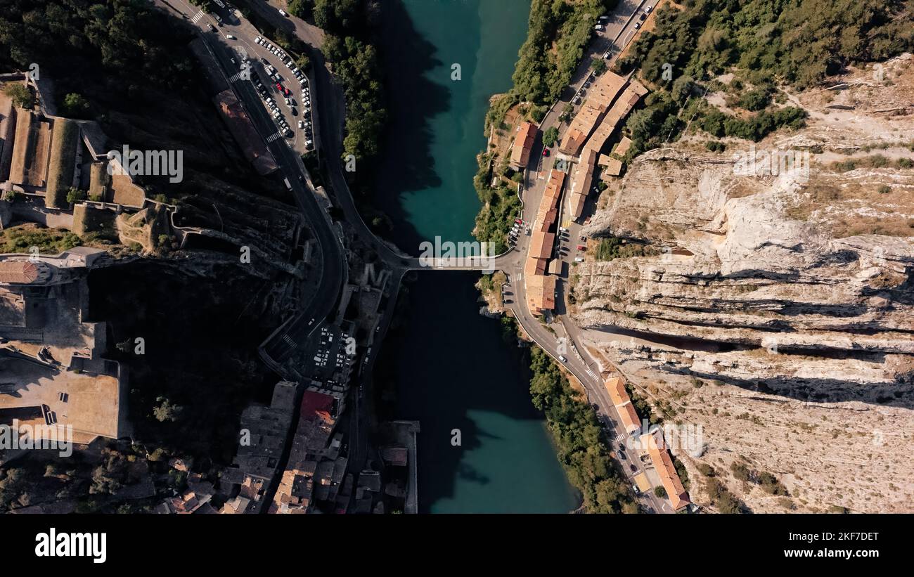 An aerial shot of a river flowing between a small town in southern ...