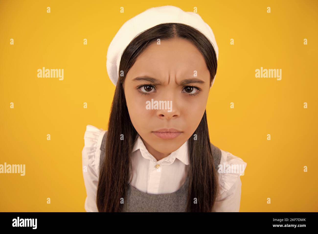Portrait of angry teen girl looking at camera isolated on studio ...