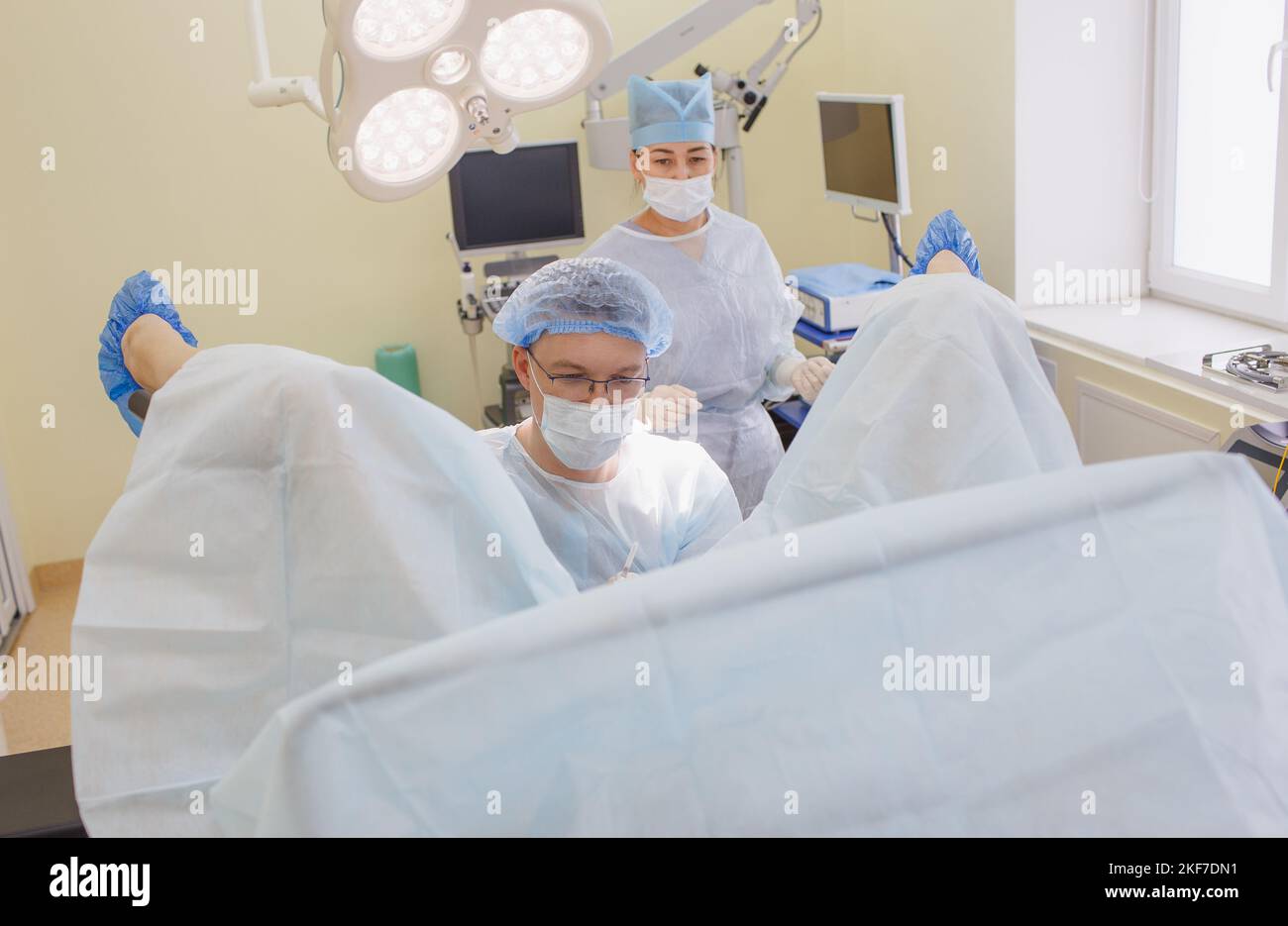 a proctologist and a nurse perform an operation in the operating room ...