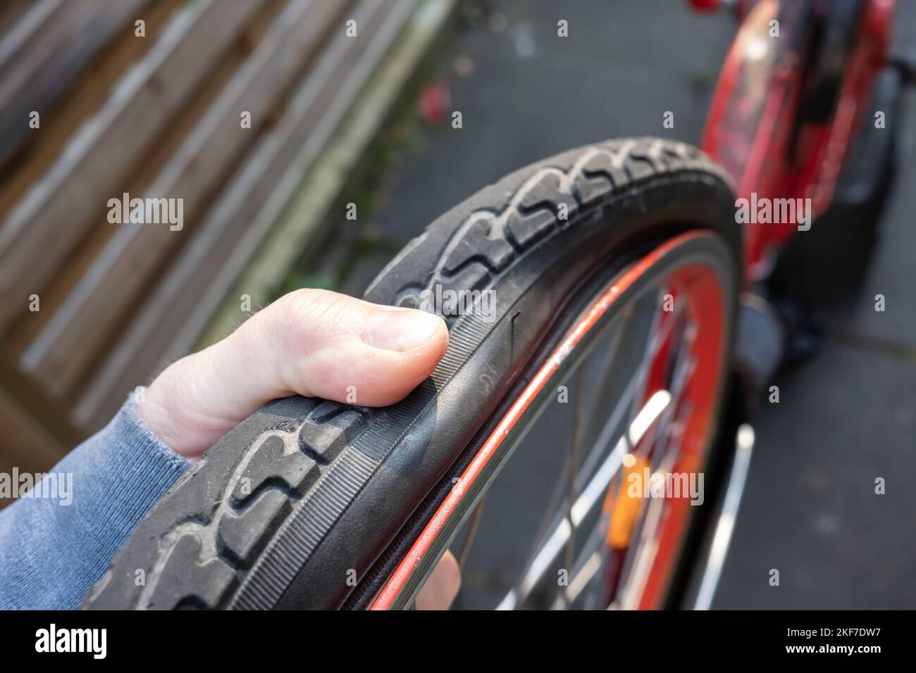 Punctured bicycle wheel. Cyclist presses finger on the tire and checks ...