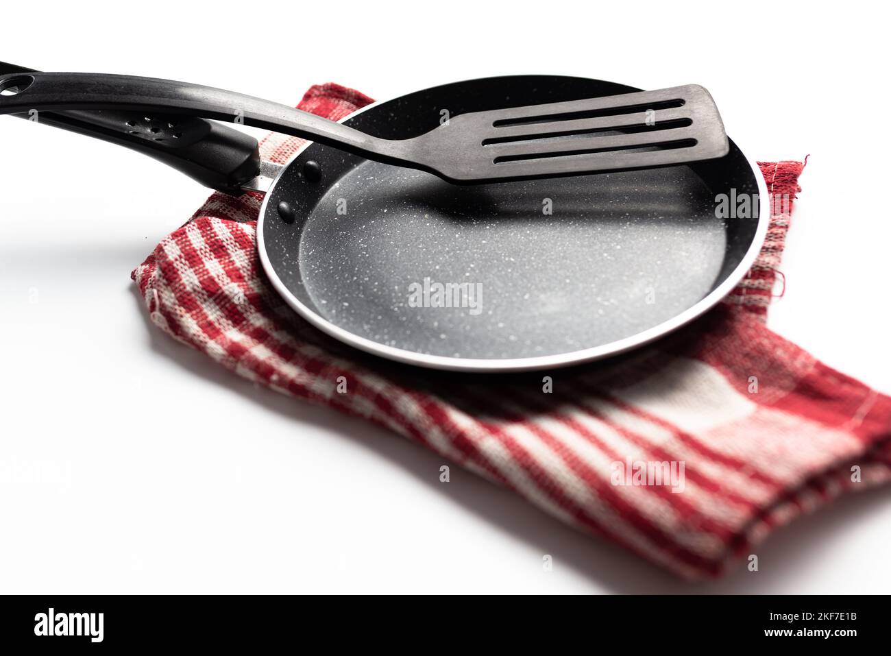 frying pan and kitchen spatula on white background Stock Photo - Alamy