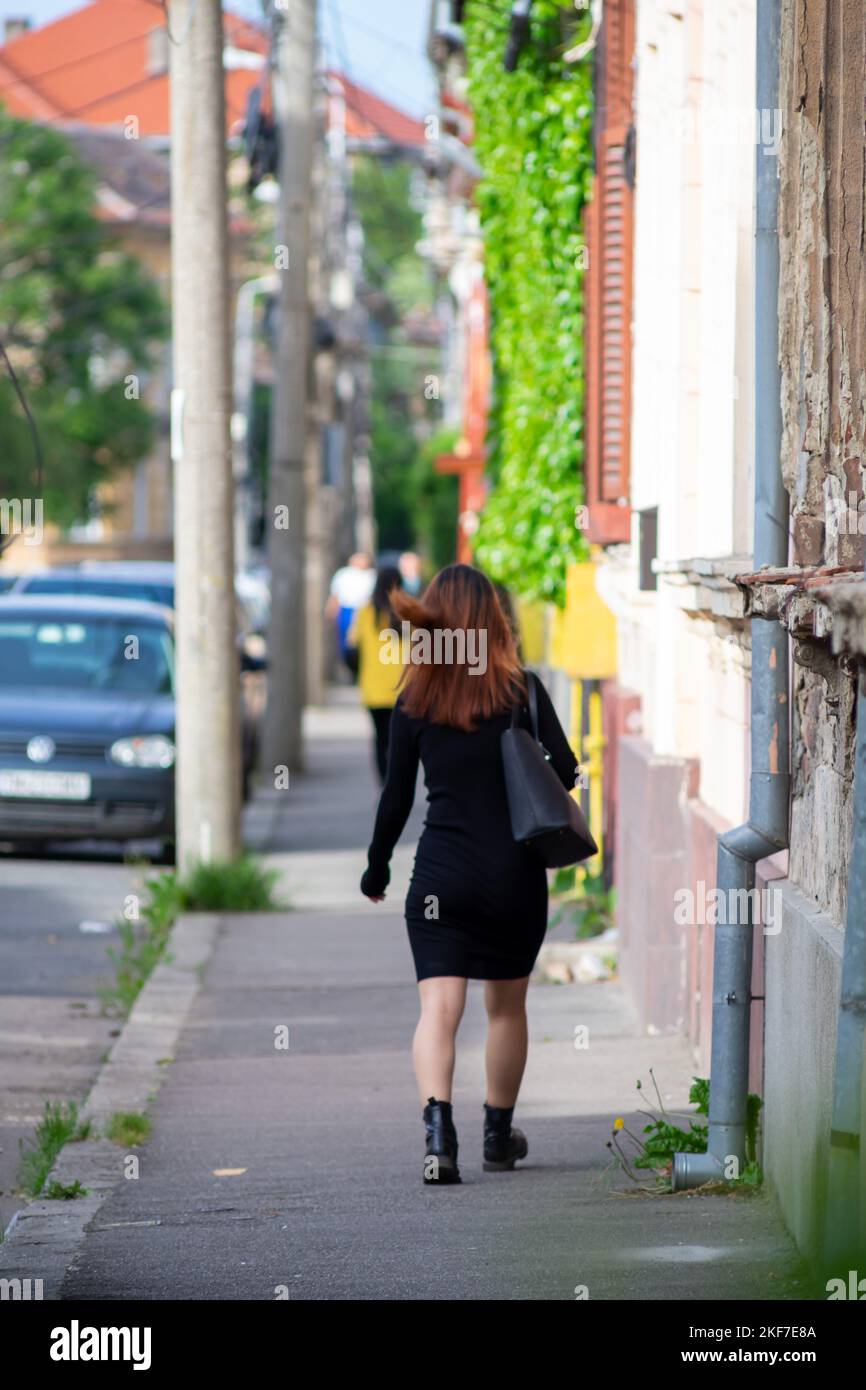 Woman walking on the street. View from behind. Real people Stock Photo ...