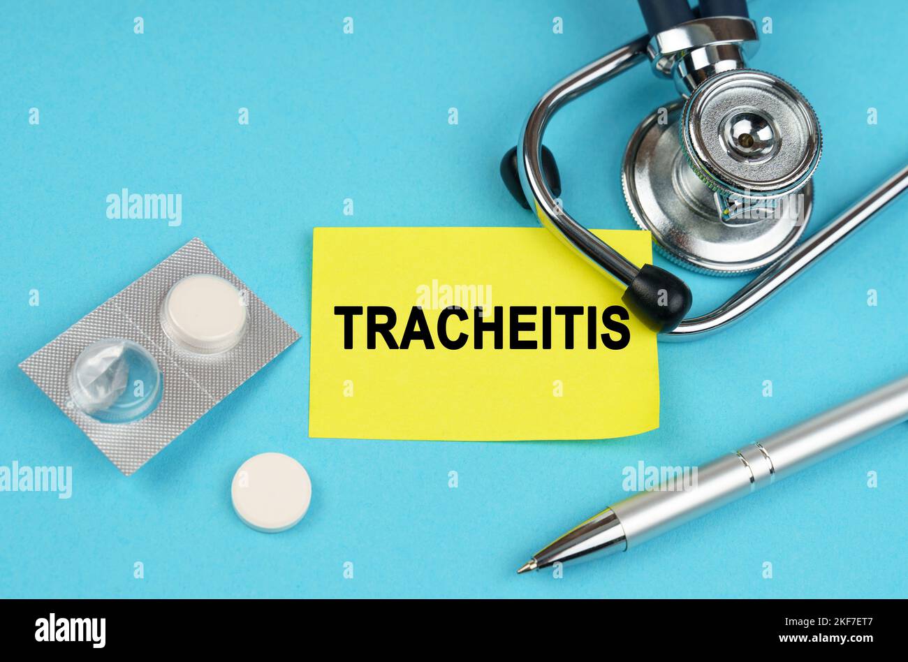 Medical concept. On a blue surface, a stethoscope, pills, a pen and a ...