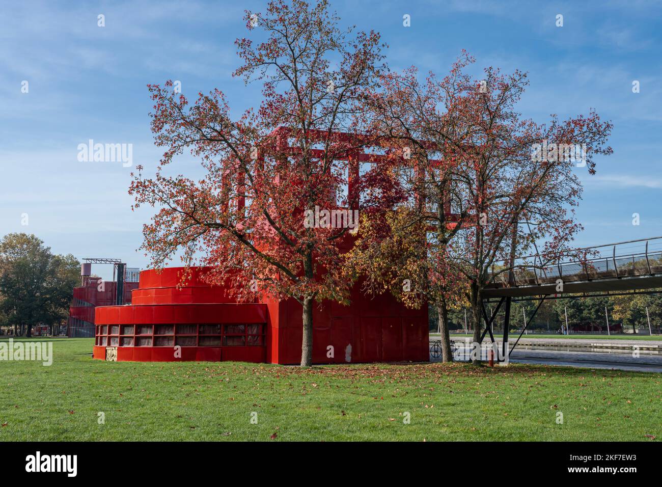 View of colored trees in autumn and a red building behind Stock Photo ...