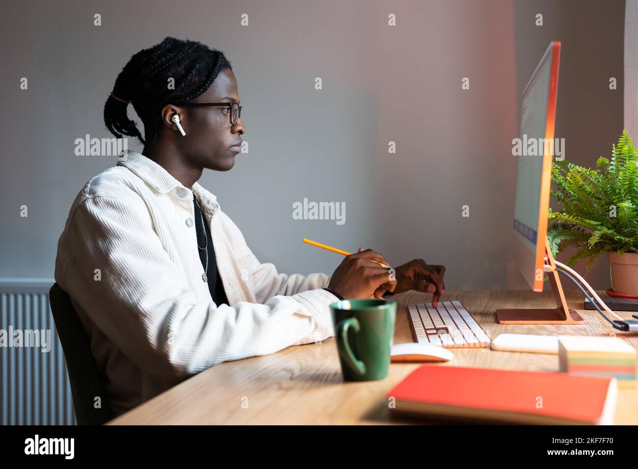 Progressive focused African American man designer working sits at ...