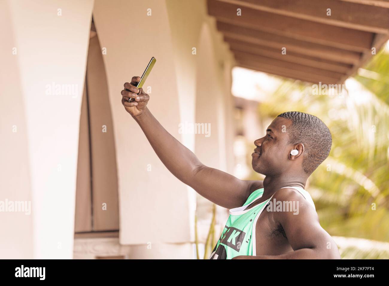 Side view of black male tourist listening to music in true wireless ...