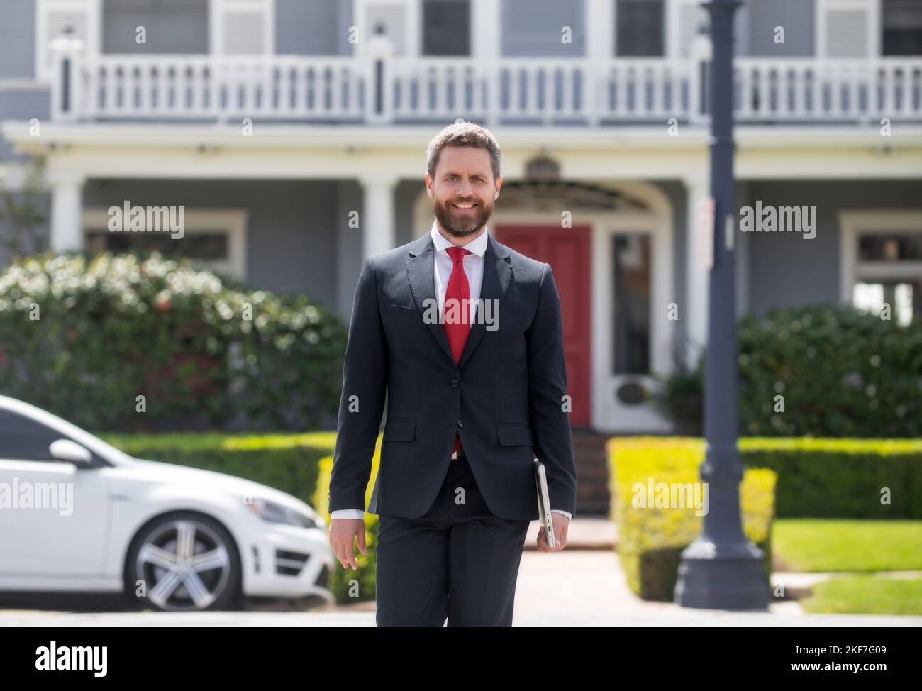 Businessman standing outside a modern house. Real estate concept. Agent ...