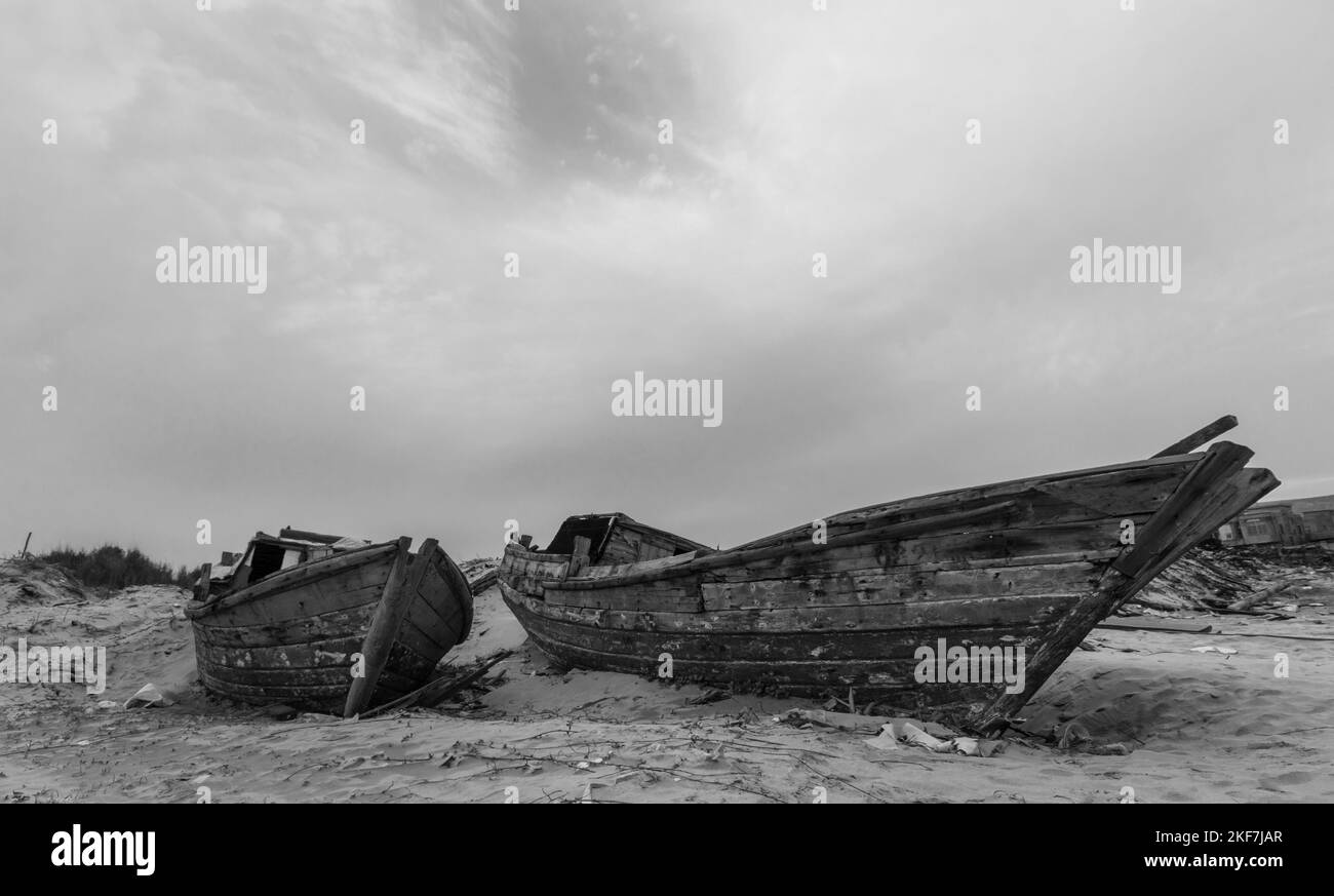 A black and white shot of abandoned boats on the beach Stock Photo - Alamy