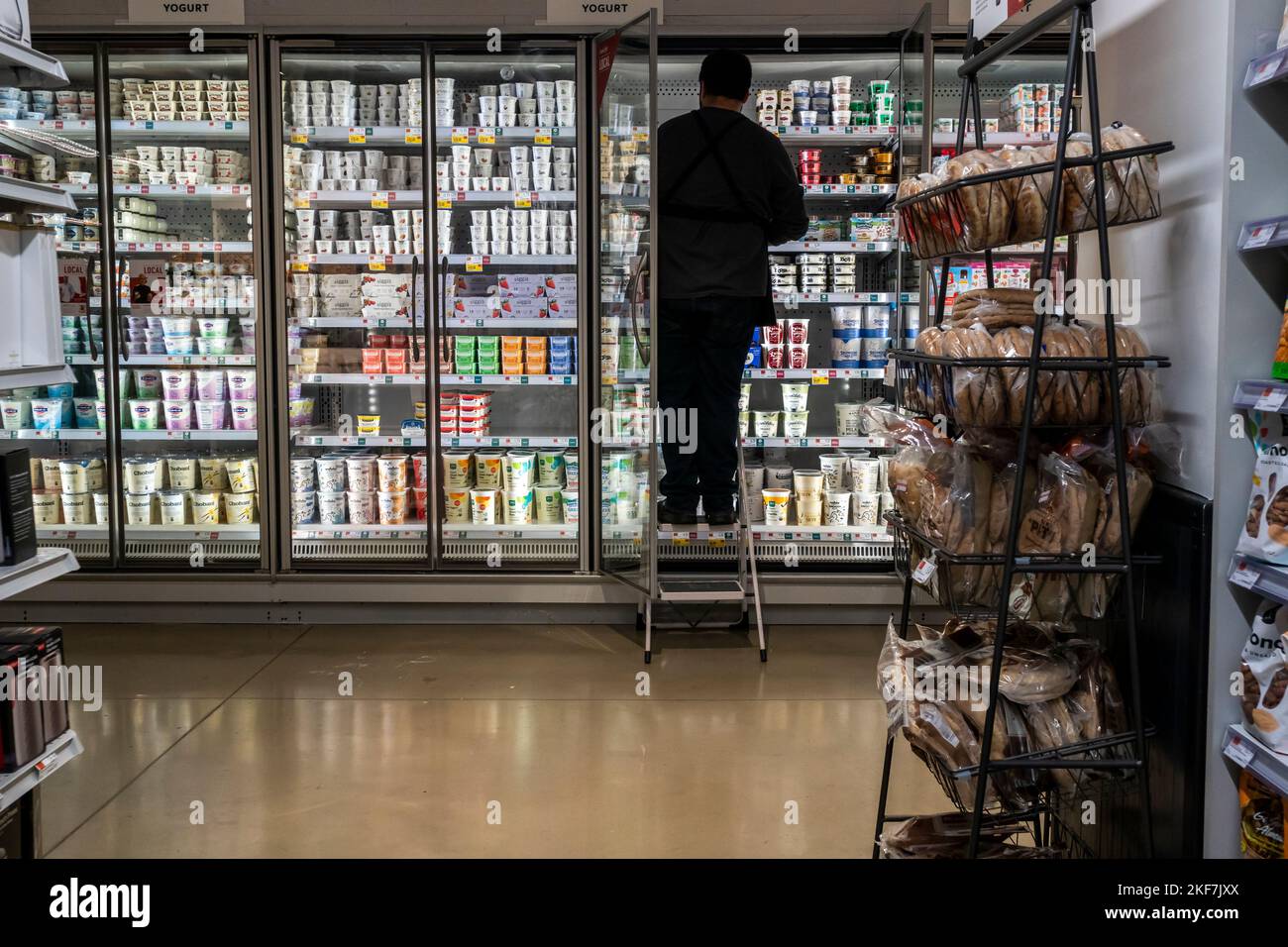 A worker stocks the dairy cooler in a Whole Foods supermarket in New ...