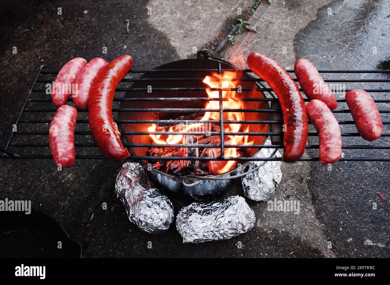 Do it yourself backyard BBQ grill in a bucket with sausages and ...