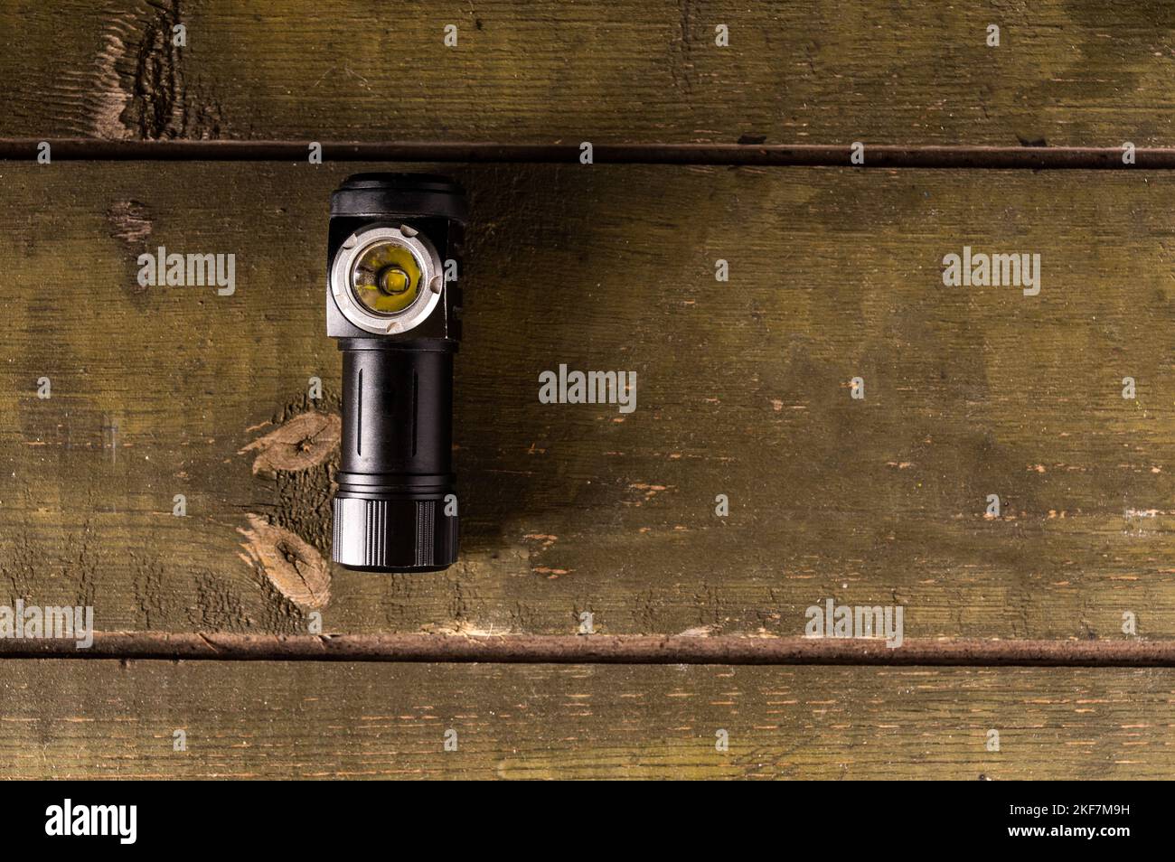 Small flashlight. Lantern lying on a green military box. Curved lantern ...