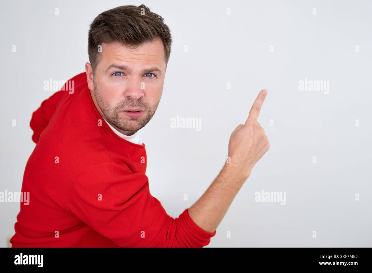 Serious man pointing finger up showing logo promo aside, pay attention ...