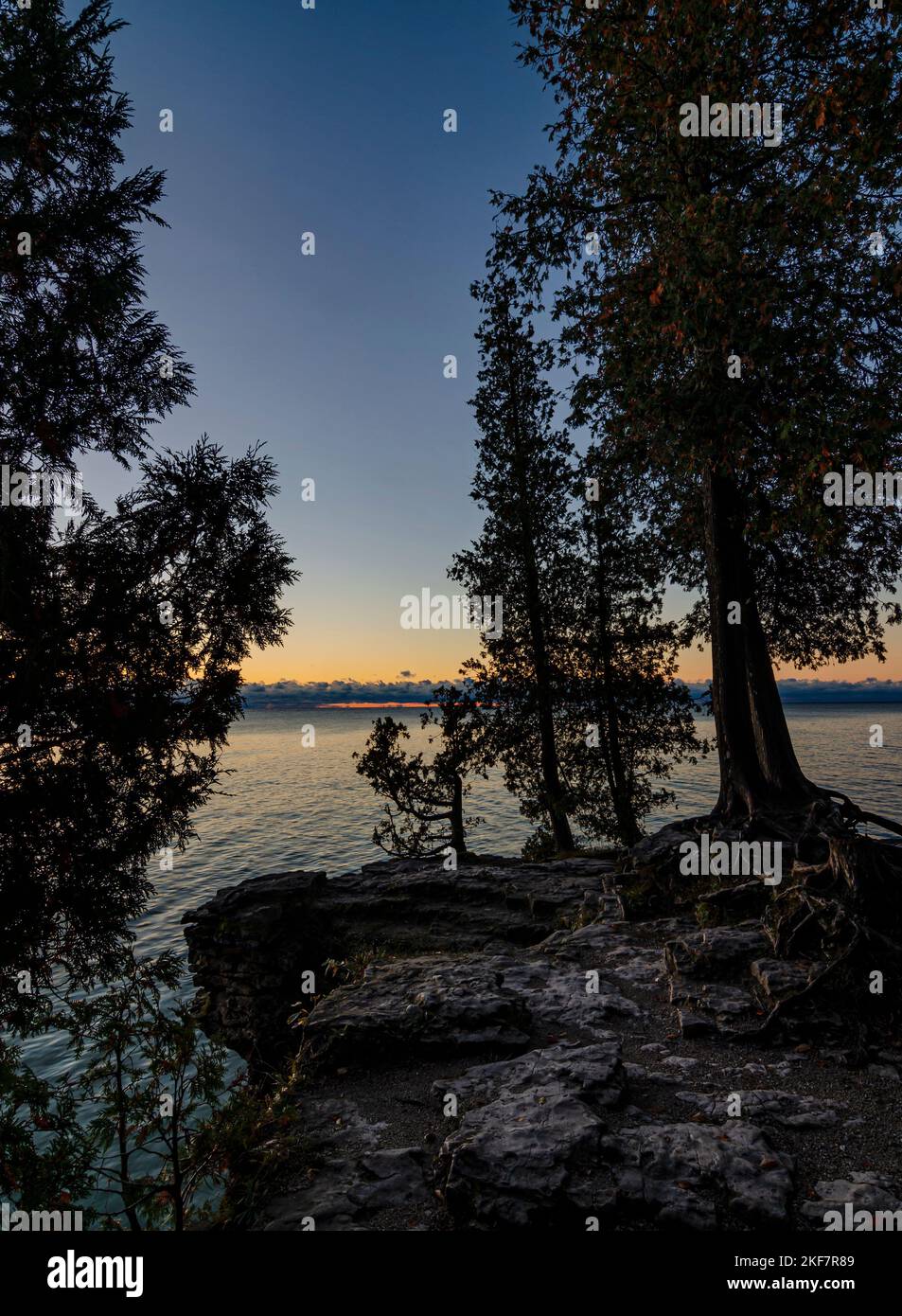 The coming dawn breaks over Lake Michigan behind a bank of clouds on ...