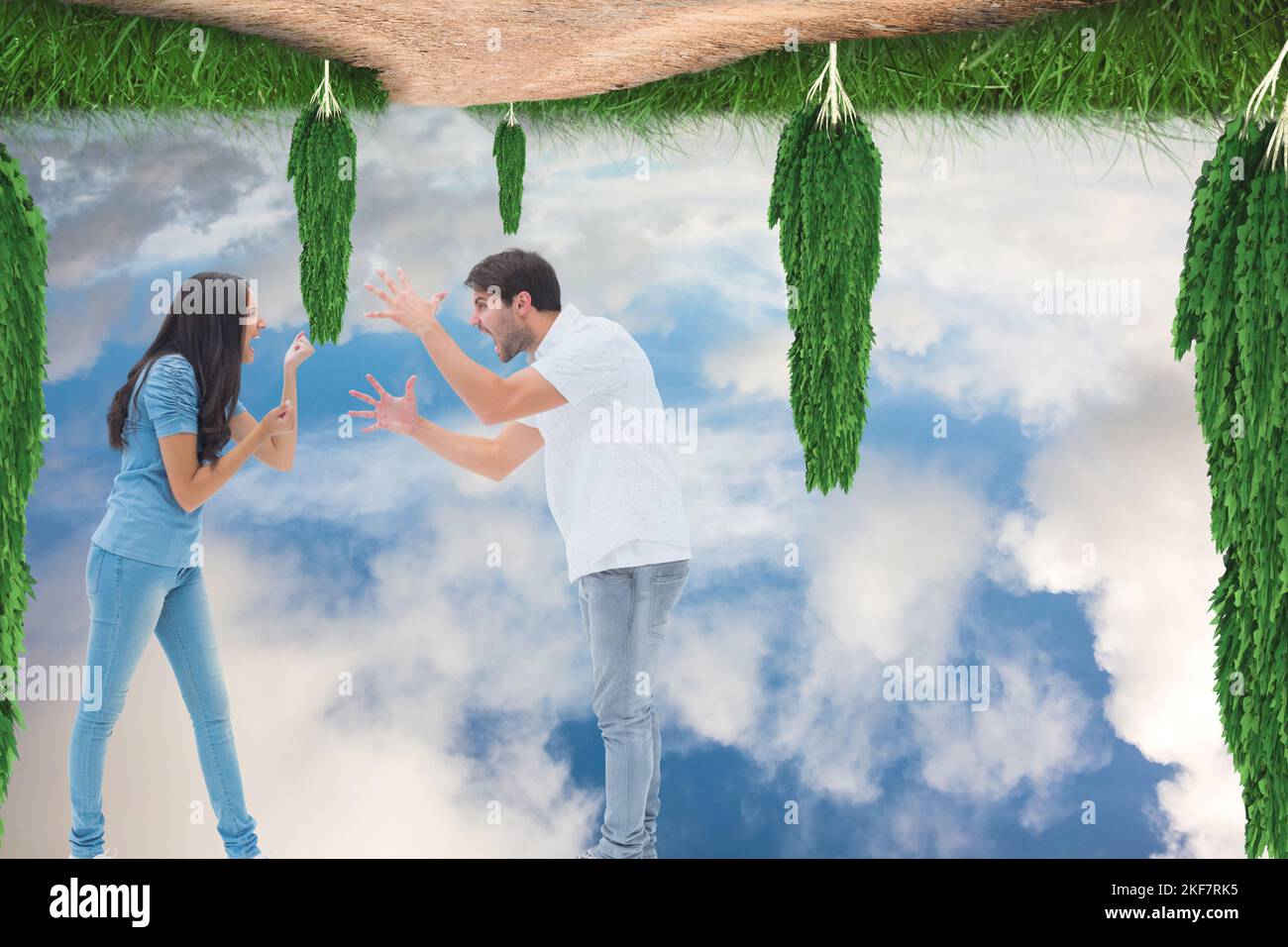 Caucasian couple arguing against upside down trees and and blue sky ...