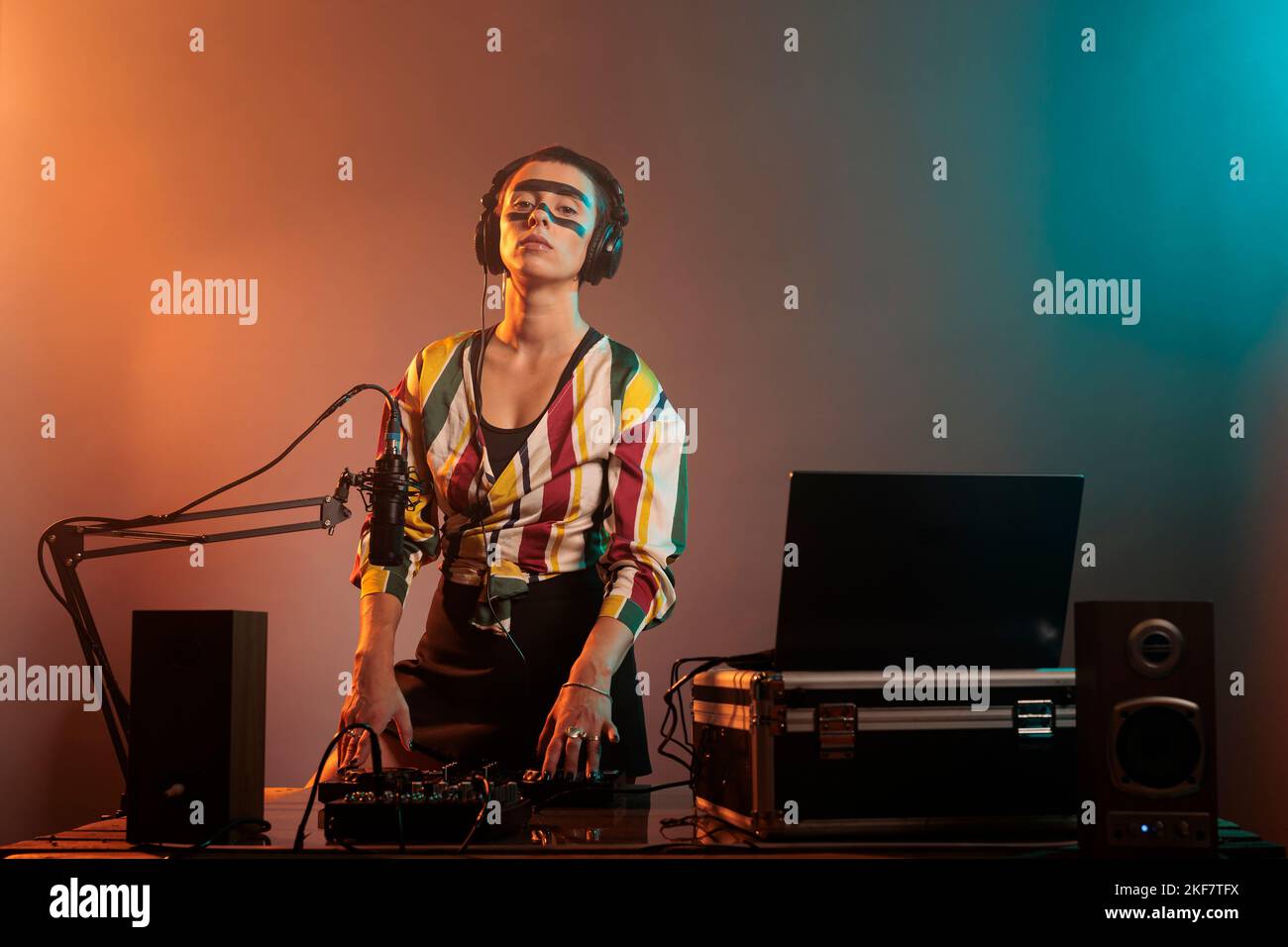 Cheerful musical artist working as dj with turntables, mixing techno ...