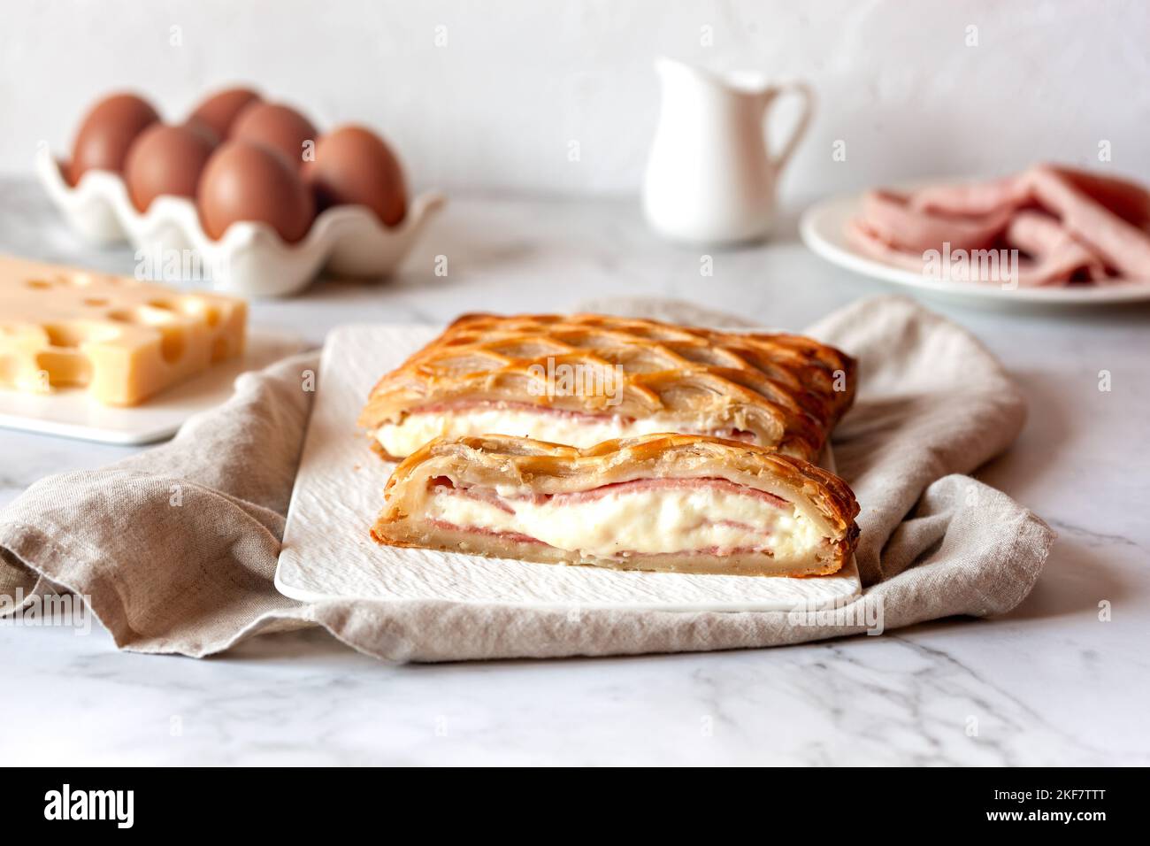 puff with ham and cheese cut on a rectangular plate on a kitchen table ...