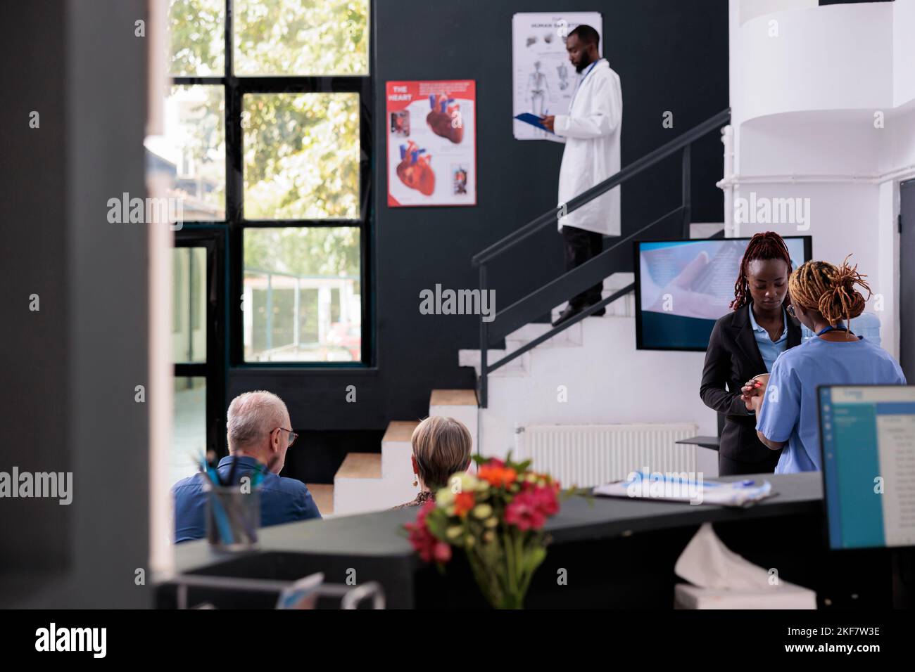Medical assistant talking with receptionist discussing patients ...